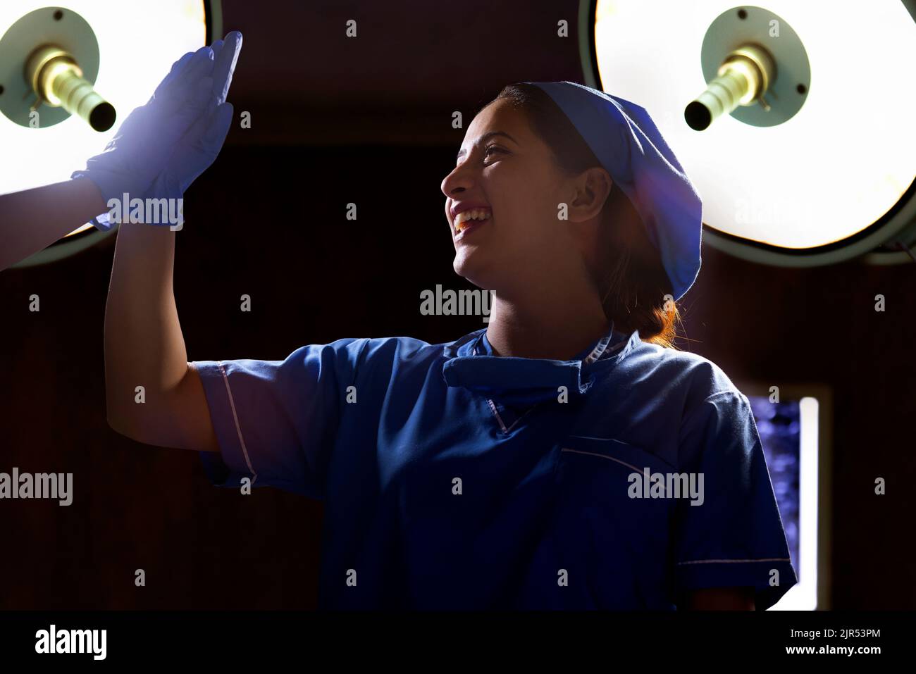 Portrait of happy female nurse giving high five after successful ...