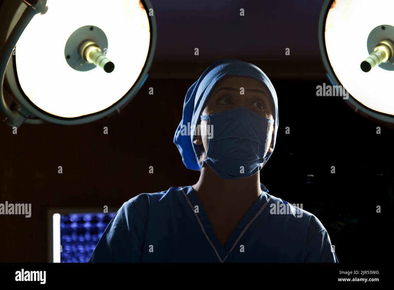 Portrait of female nurse with face mask on operating room at hospital ...