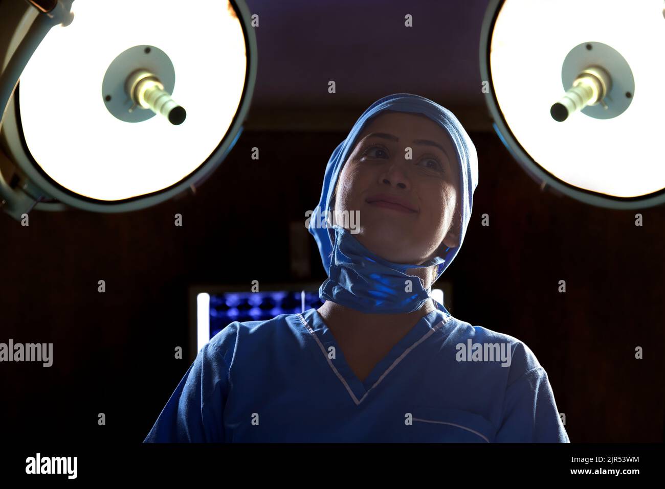 Portrait of female nurse with face mask on operating room at hospital ...
