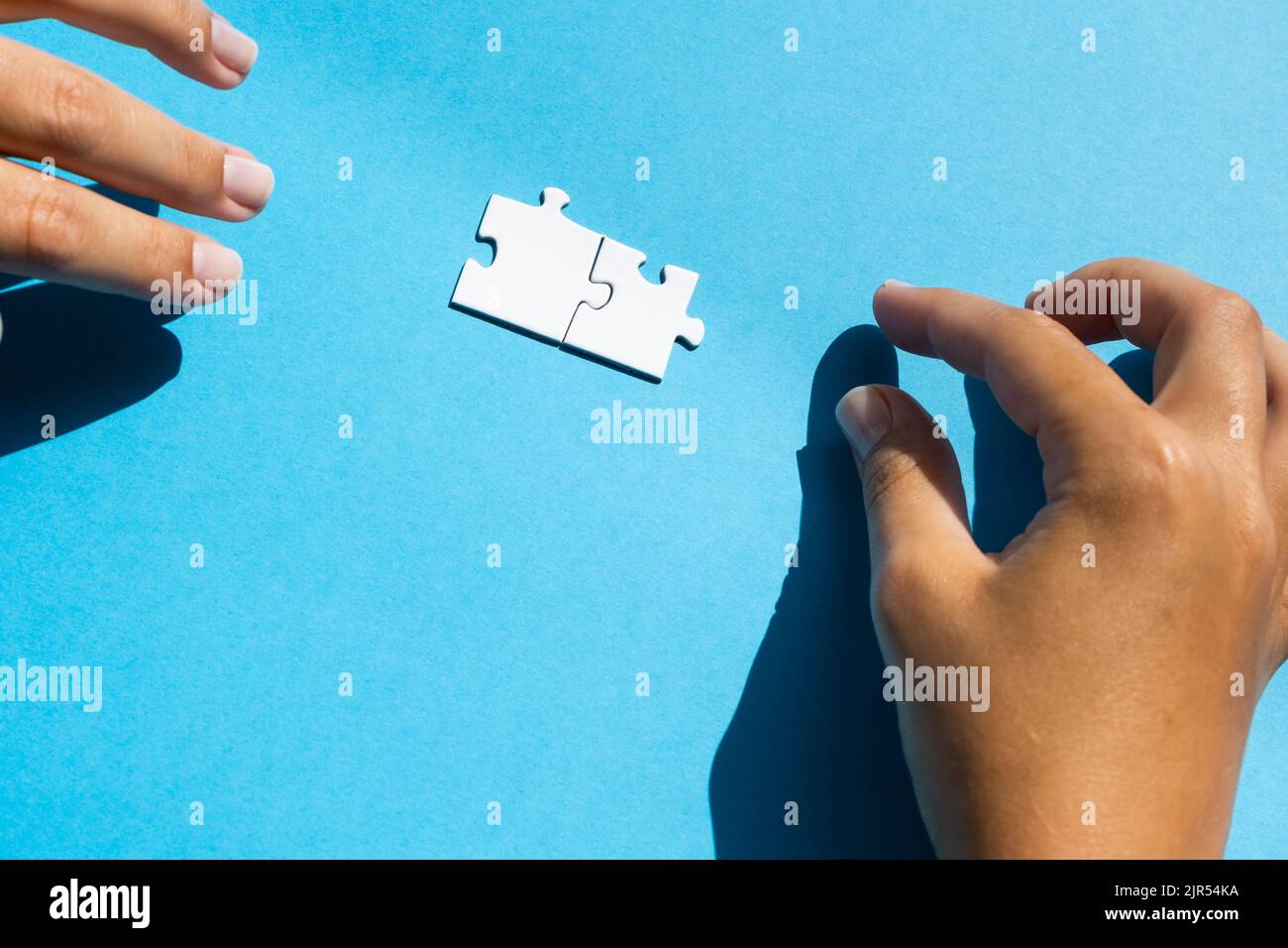 Hand join the piece of jigsaw puzzle to complete the line Stock Photo ...
