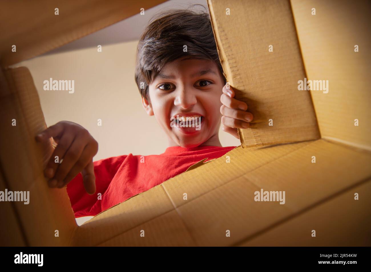 Portrait of boy opening a cardboard box Stock Photo - Alamy