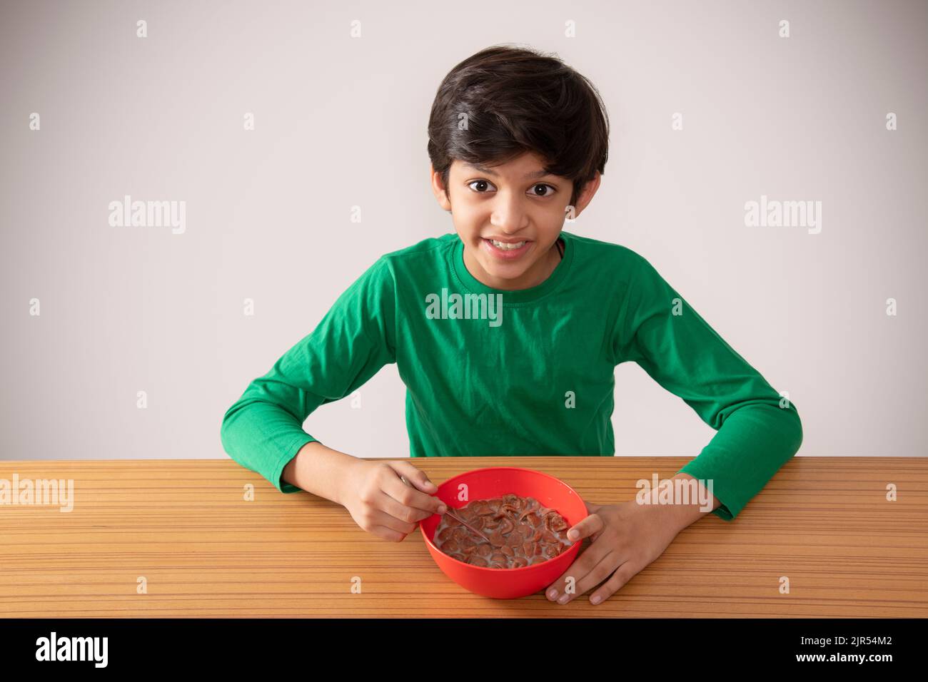 Portrait of an excited boy eating milk chocos Stock Photo - Alamy