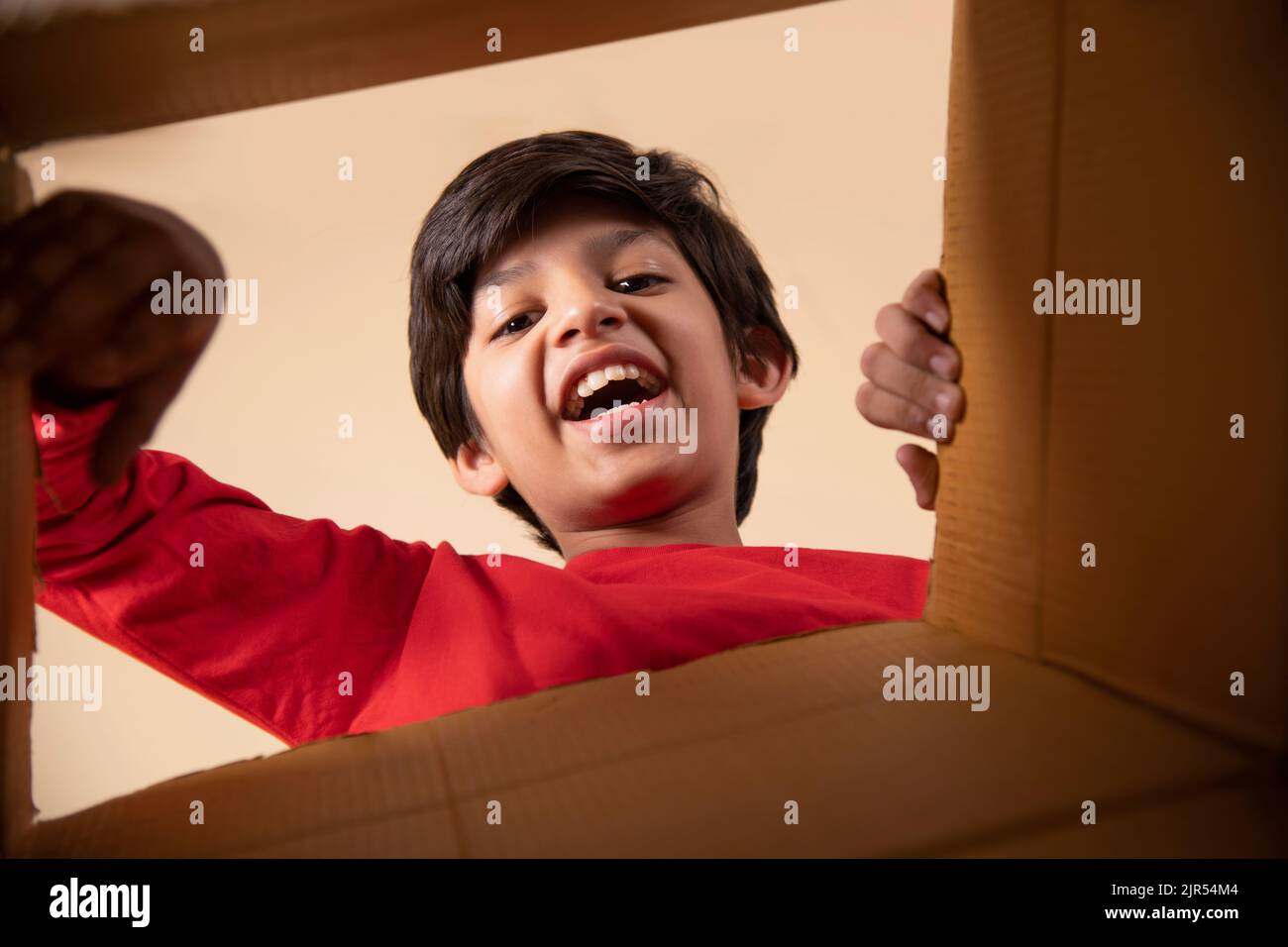 Portrait of boy opening a cardboard box Stock Photo - Alamy