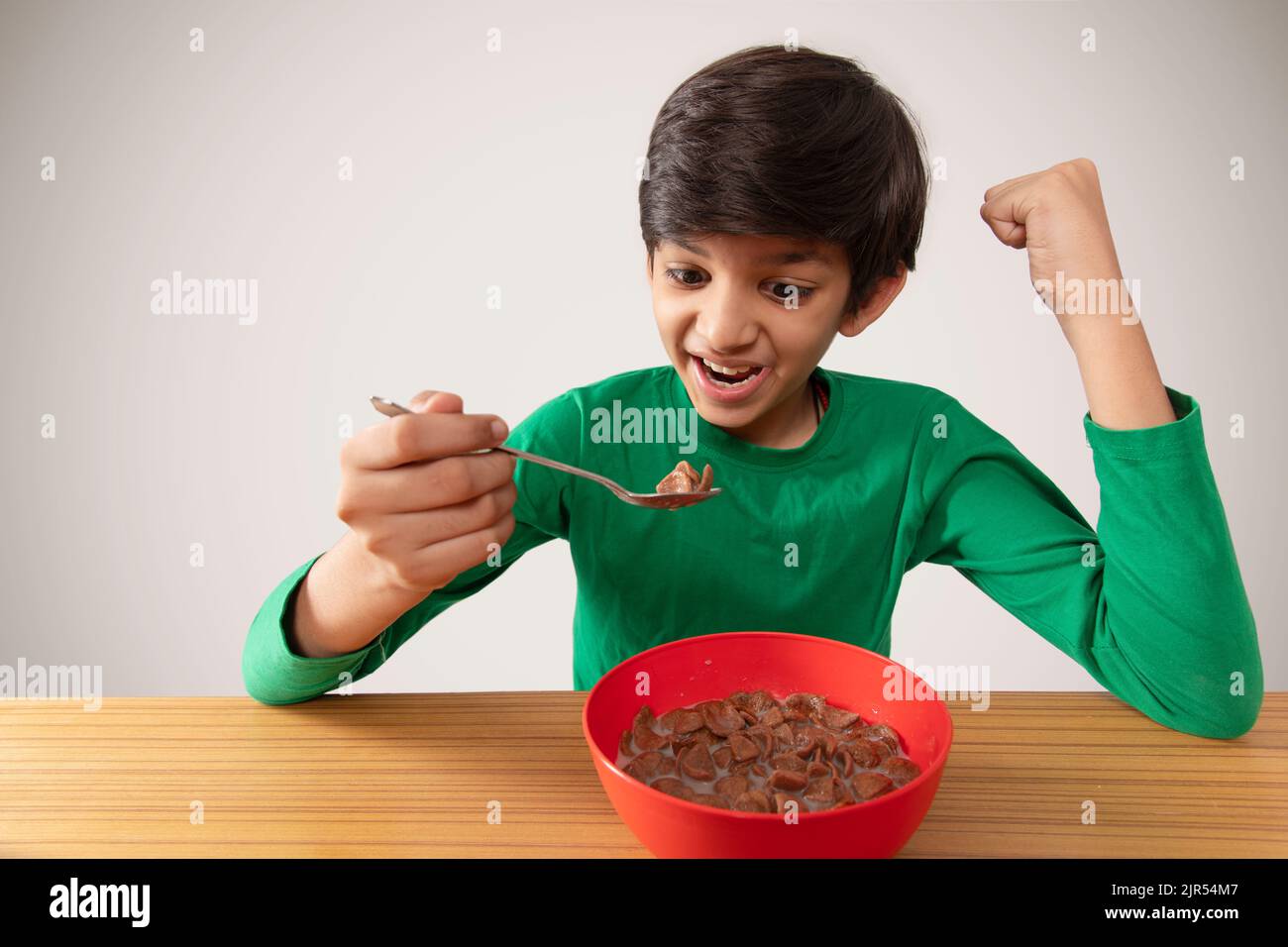 Portrait of an excited boy eating milk chocos Stock Photo - Alamy
