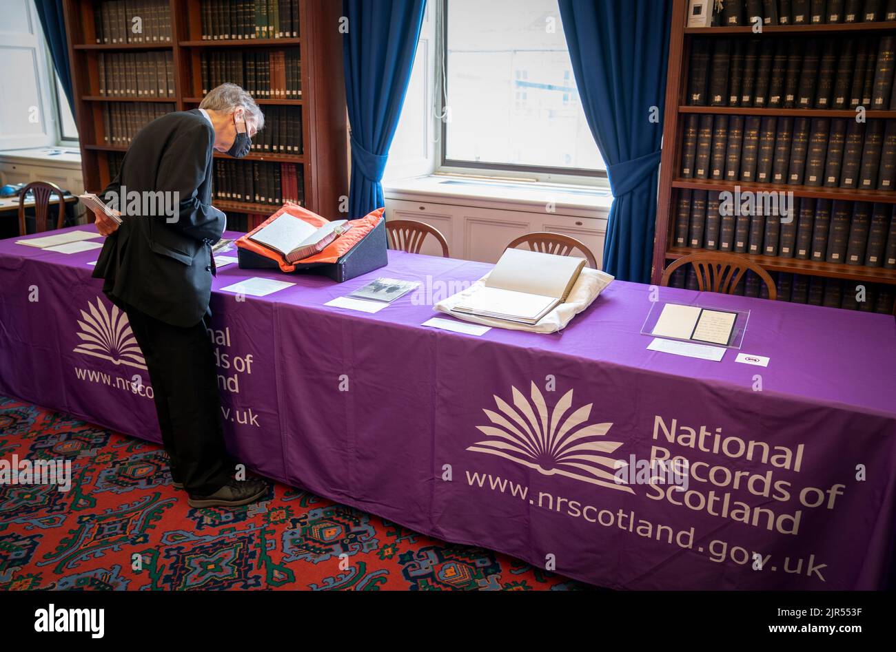 A visitor looks at some of the documents and photographs on display at ...