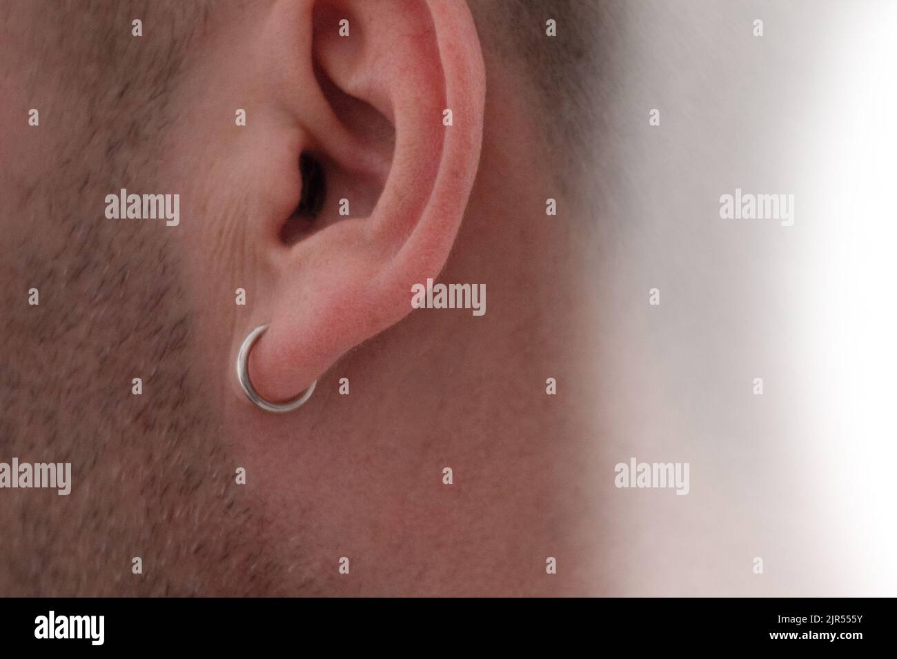 Earring in the ear, Close-up, Piercing in the ear Men. Silver earring ...