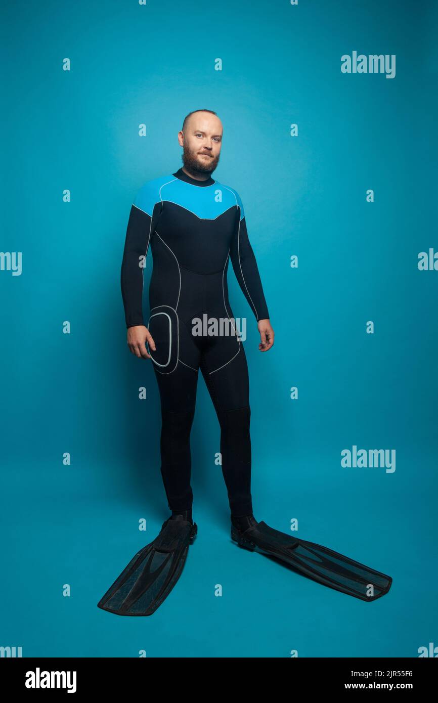 Man diver standing on blue studio background Stock Photo - Alamy
