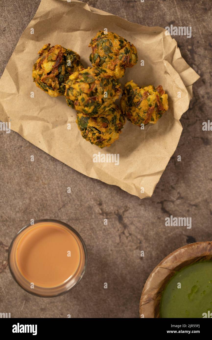 DEEP FRIED PAKORAS SERVED ON PAPER WITH TEA AND CHUTNEY Stock Photo - Alamy