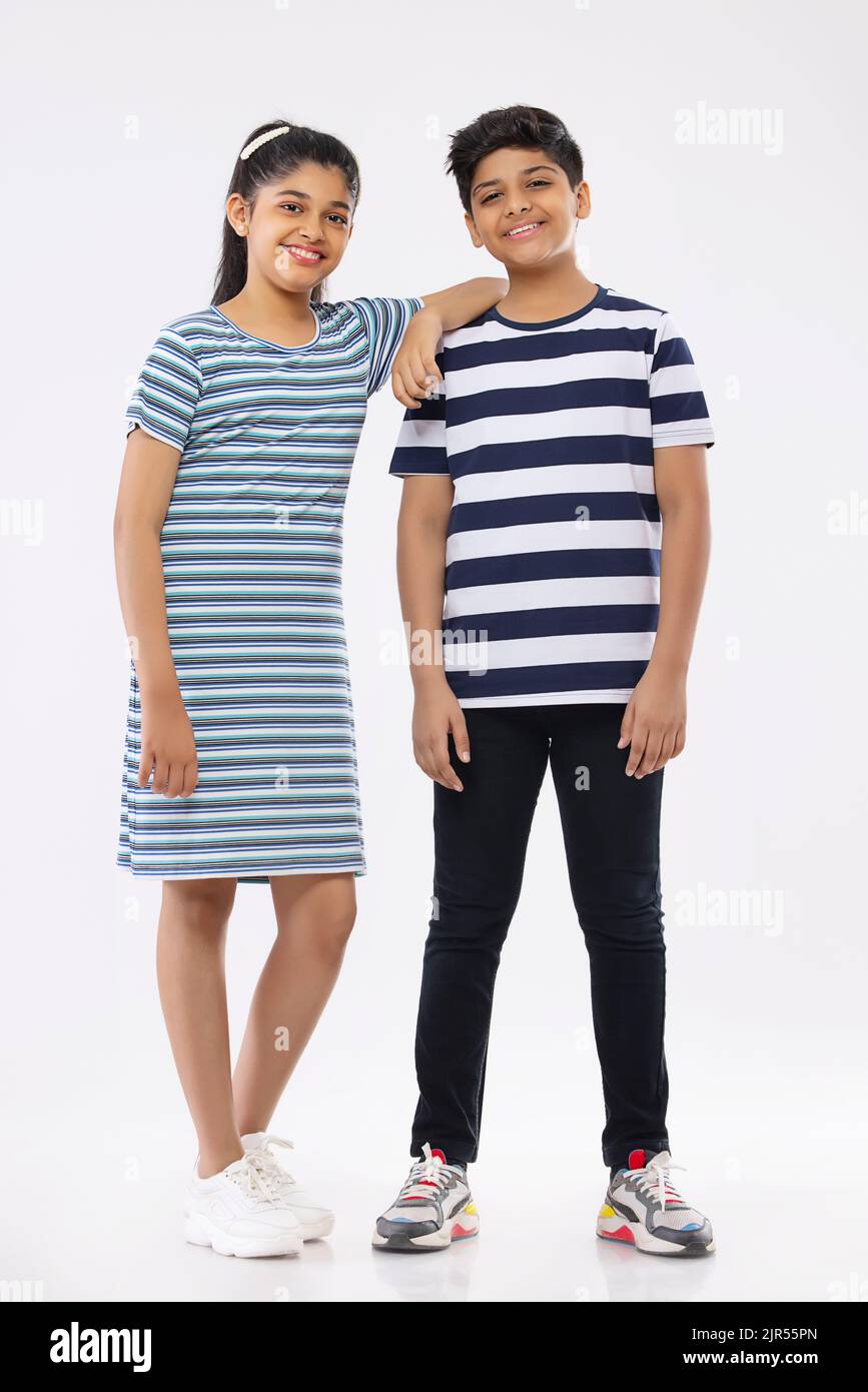 Portrait of two cheerful children standing against white background ...