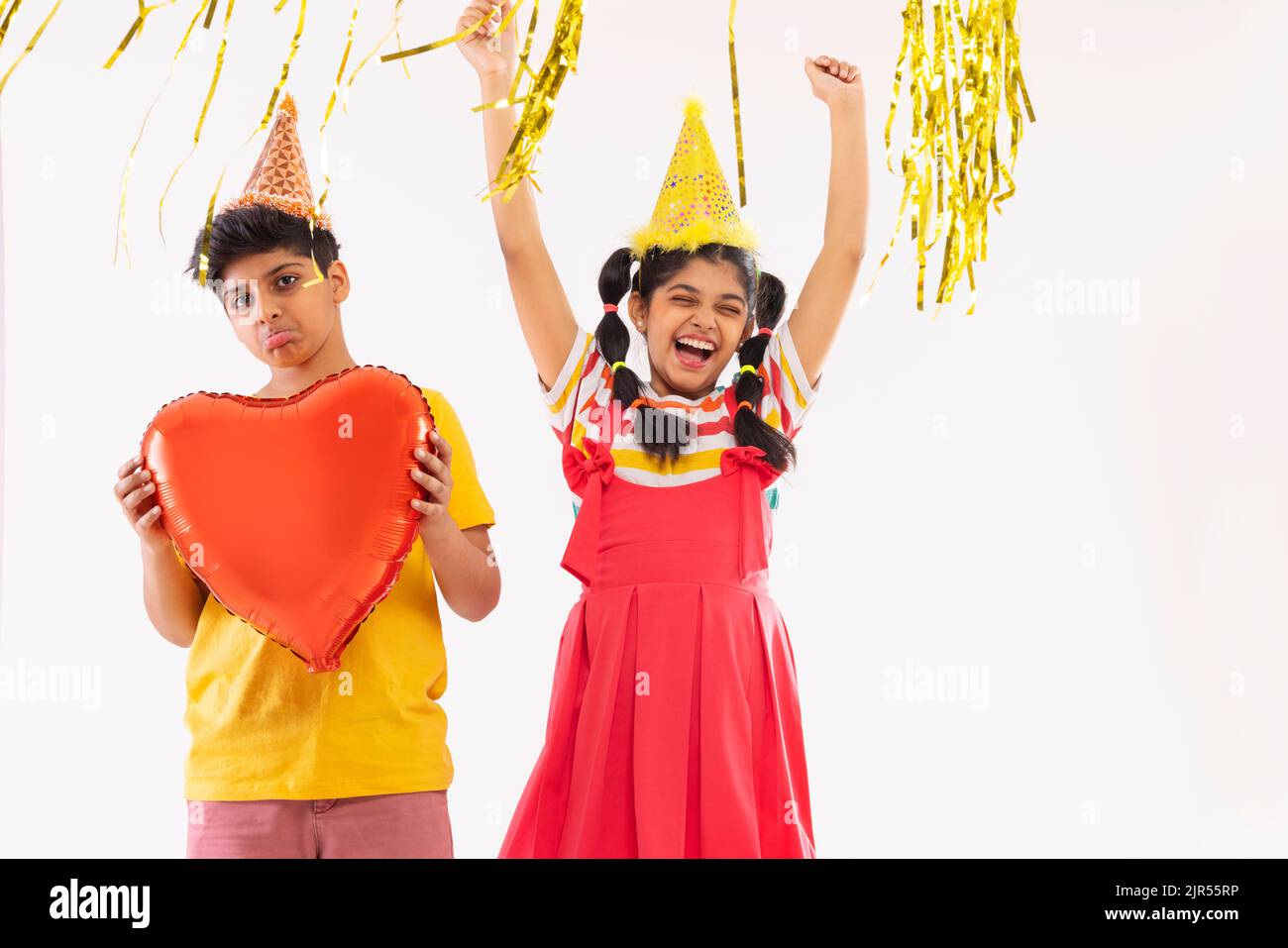 Cheerful girl celebrating and boy standing with sad facial expression ...