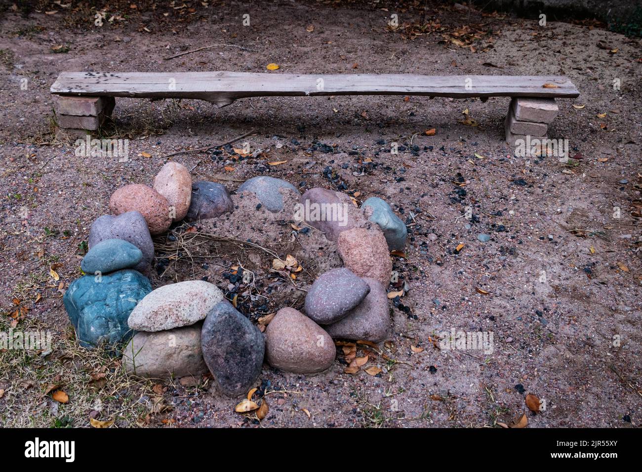 A bonfire in the circle of stones and an old wooden bench Stock Photo ...