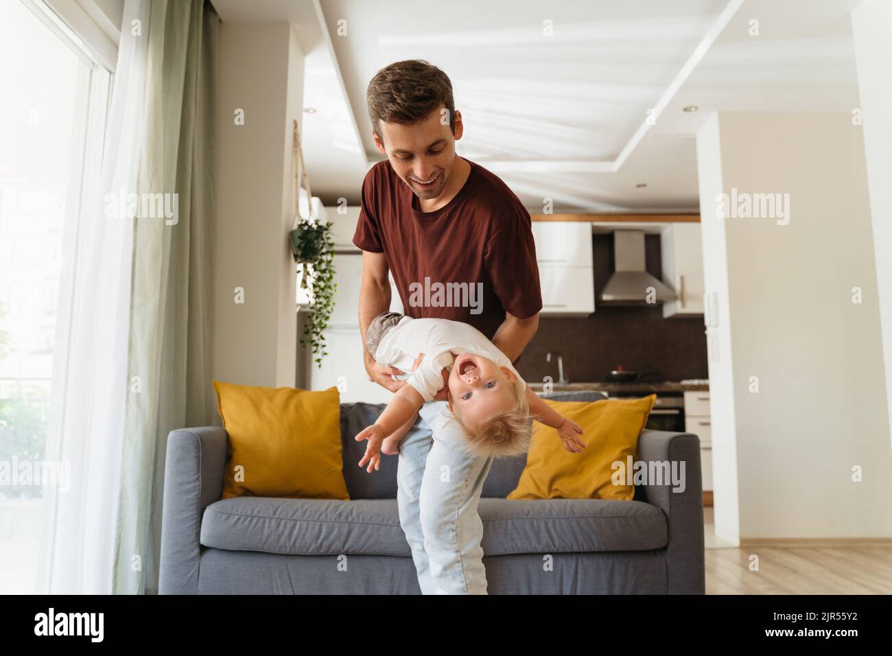 Young father spending time with his baby boy, cuddling and playing ...
