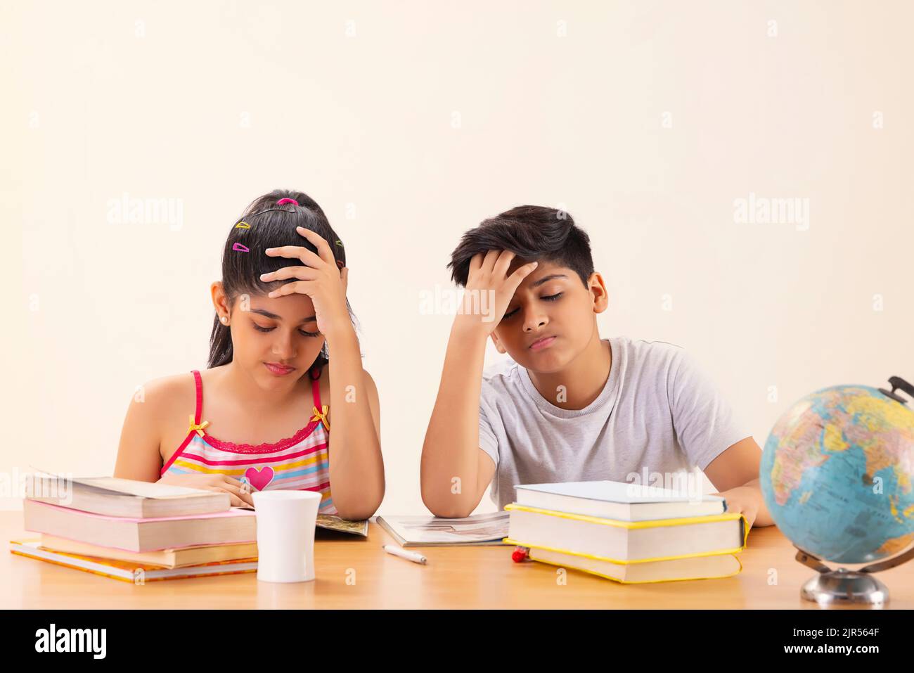 Portrait of stressed girl and boy doing homework Stock Photo - Alamy