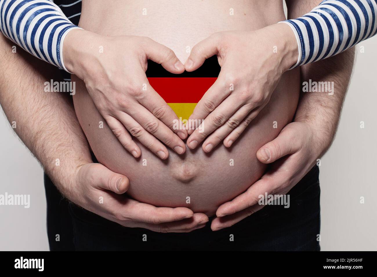 German family concept. Man embracing pregnant woman belly and heart ...