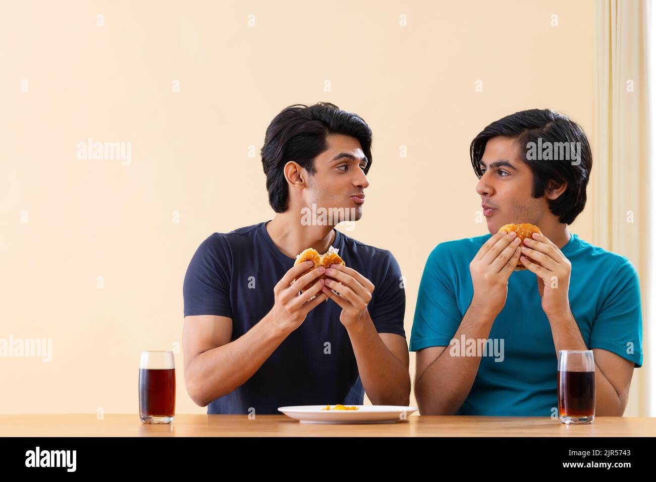 Portrait of teenage boys eating burgers together Stock Photo - Alamy