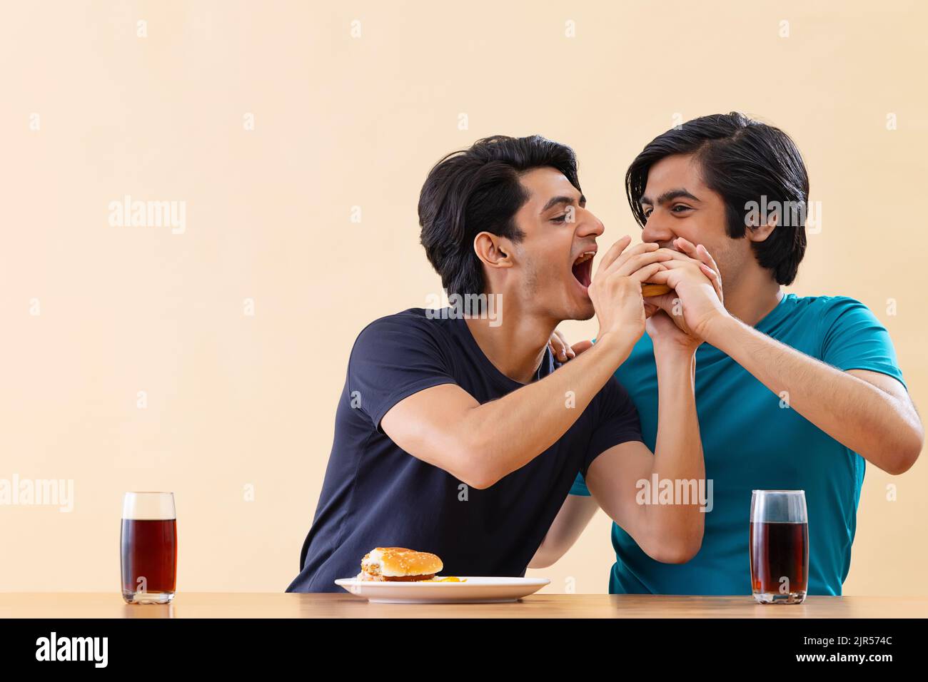 Portrait of teenage boys eating burgers together Stock Photo - Alamy