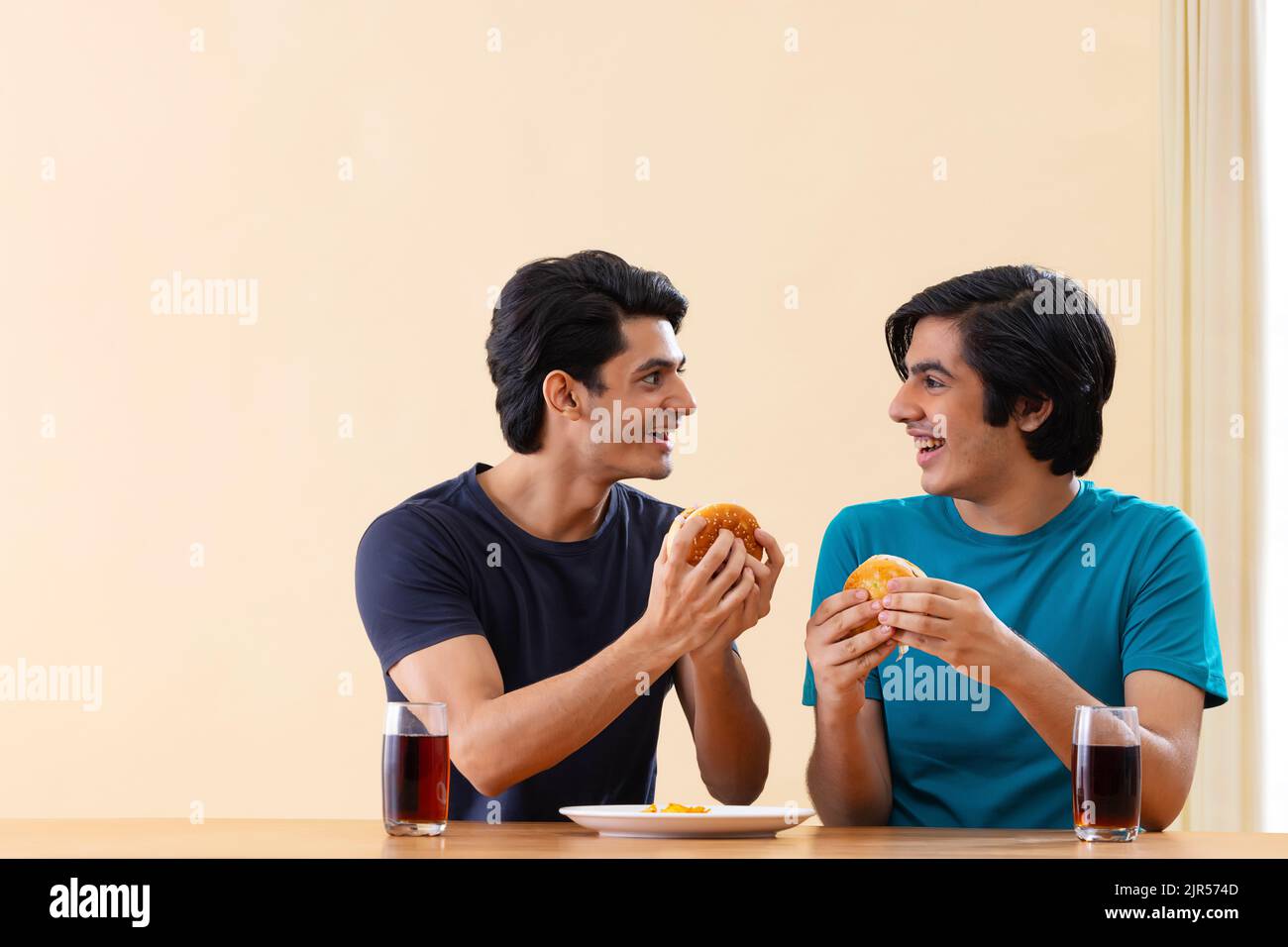 Portrait of teenage boys eating burgers together Stock Photo - Alamy