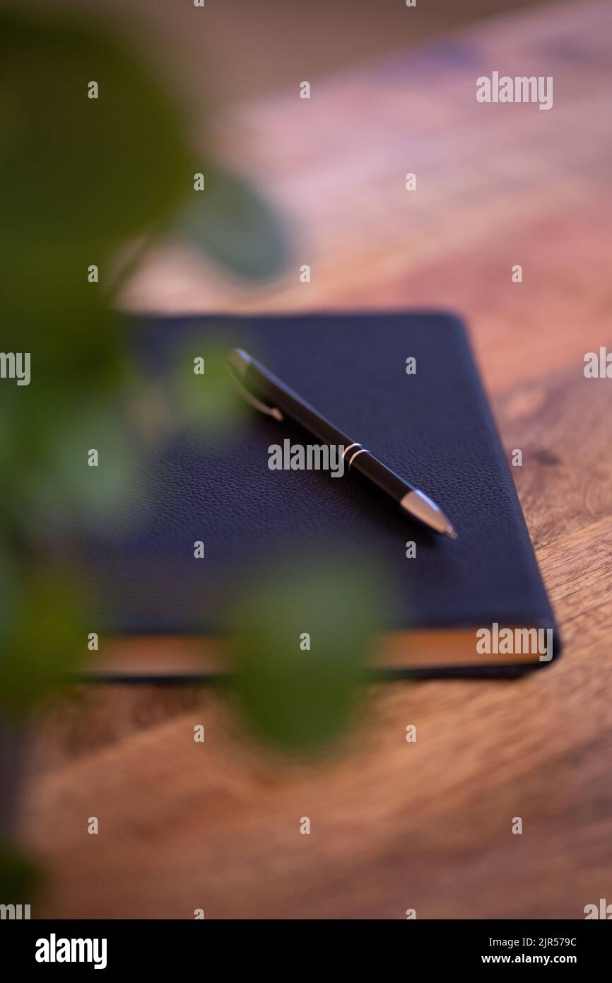 A closeup shot of a notebook and a pen on a wooden table Stock Photo ...