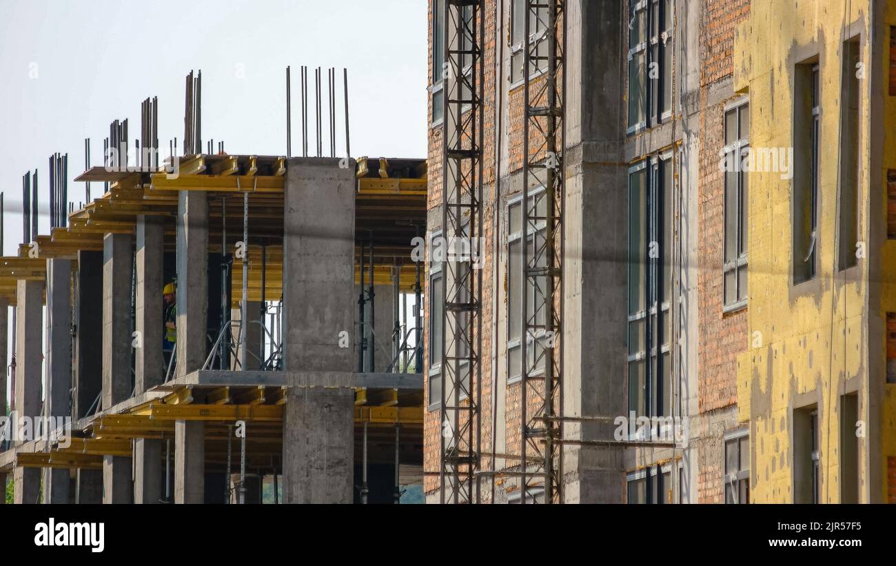 Construction workers on the floors of a skyscraper building. Men ...