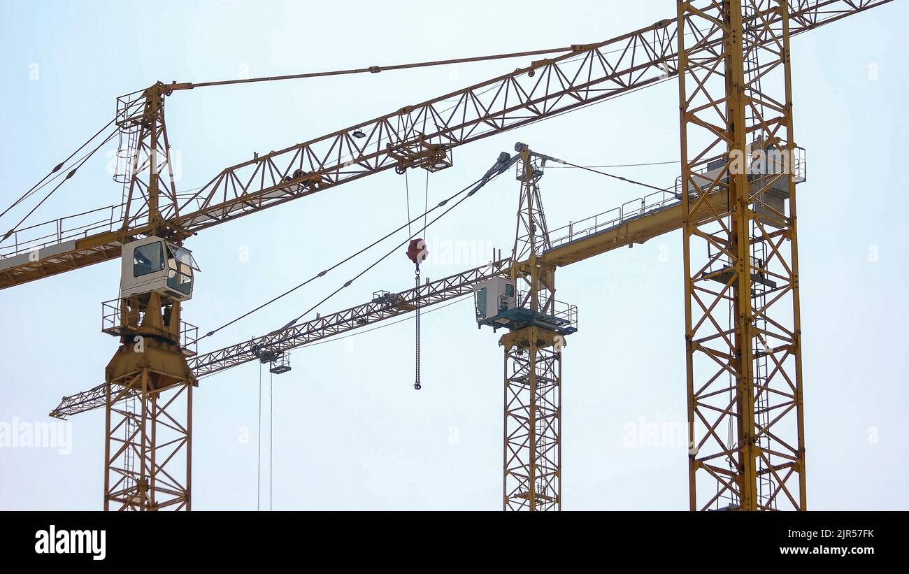 Three big yellow building crane on construction site. Morning sky ...
