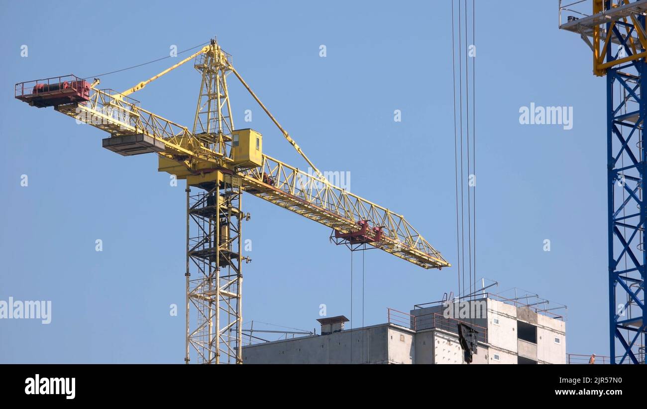 Yellow building crane on construction site. Side view of yellow crane ...