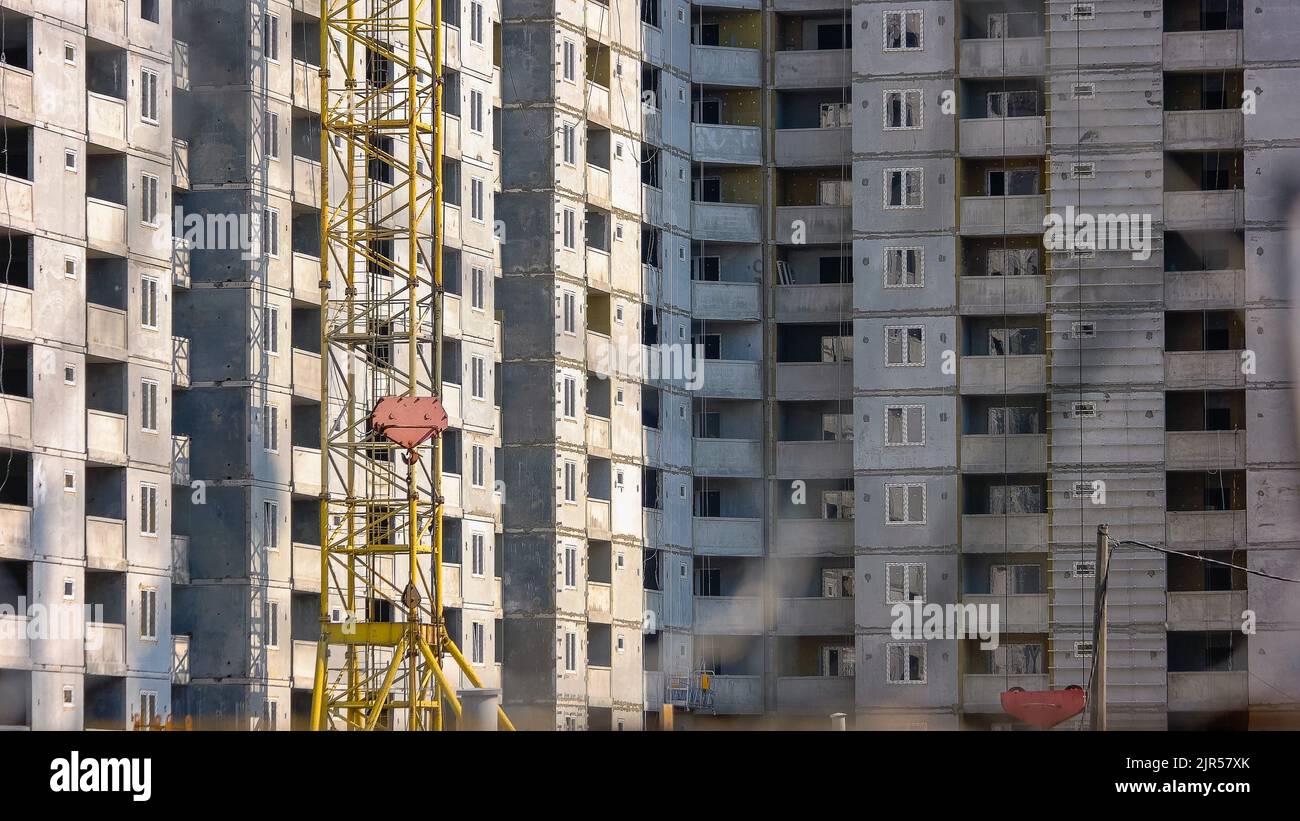 Yellow construction crane and new high-rise building. Skyscrapper under ...