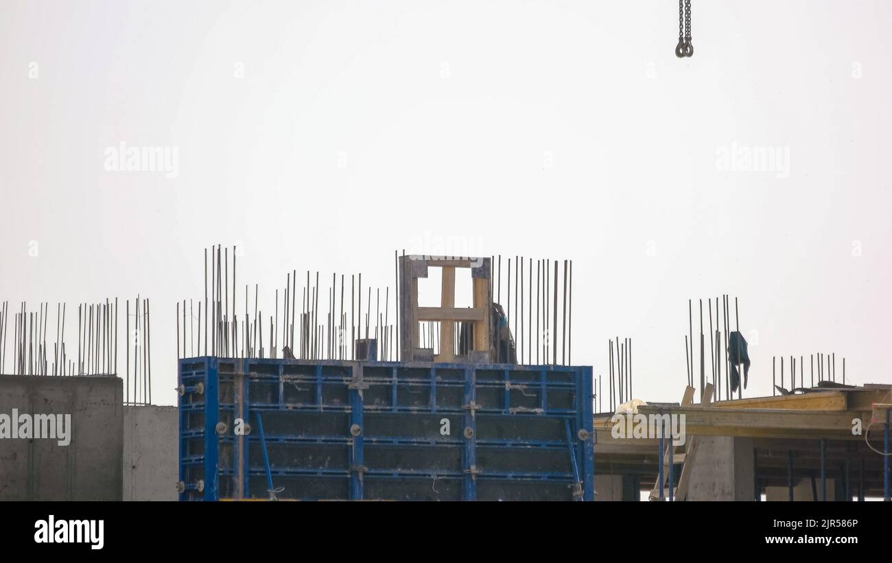 Worker is working on the building construction site. Gray sky ...