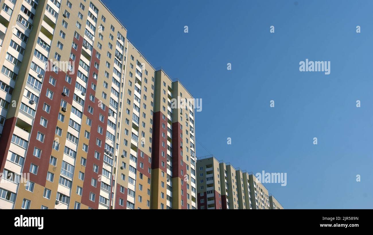 Up view of a new colored high rise building. Blue sky background Stock ...