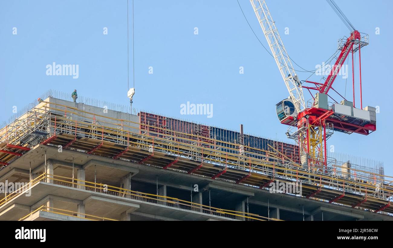 Building workers and red crane on the construction site. Fast speed ...