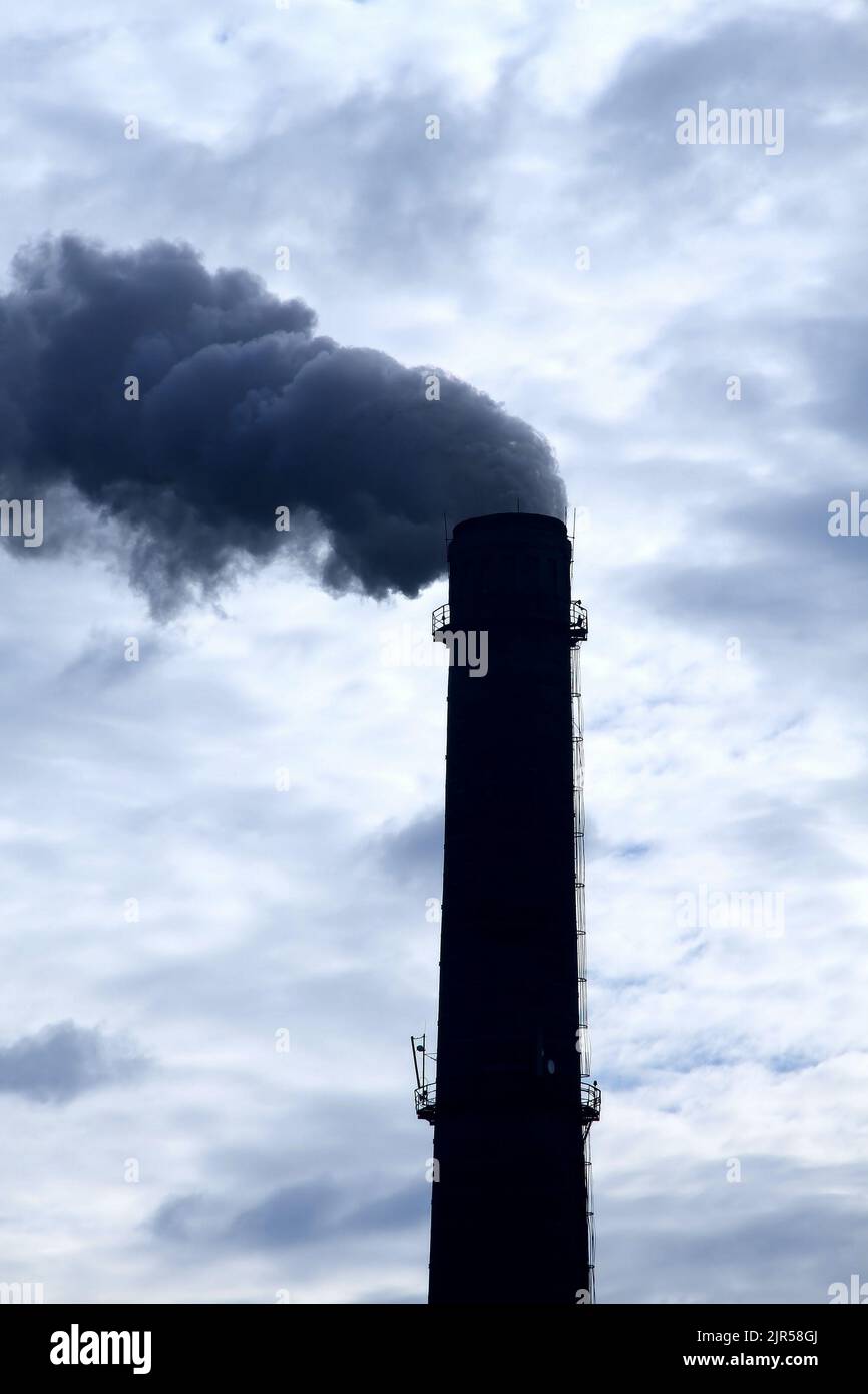 Smokestack of industrial factory polluting air under smog in the sky ...