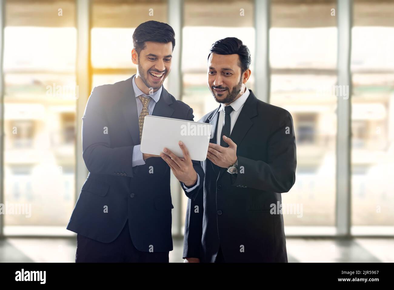 Corporate employees in formal business suit looking at a digital tablet ...