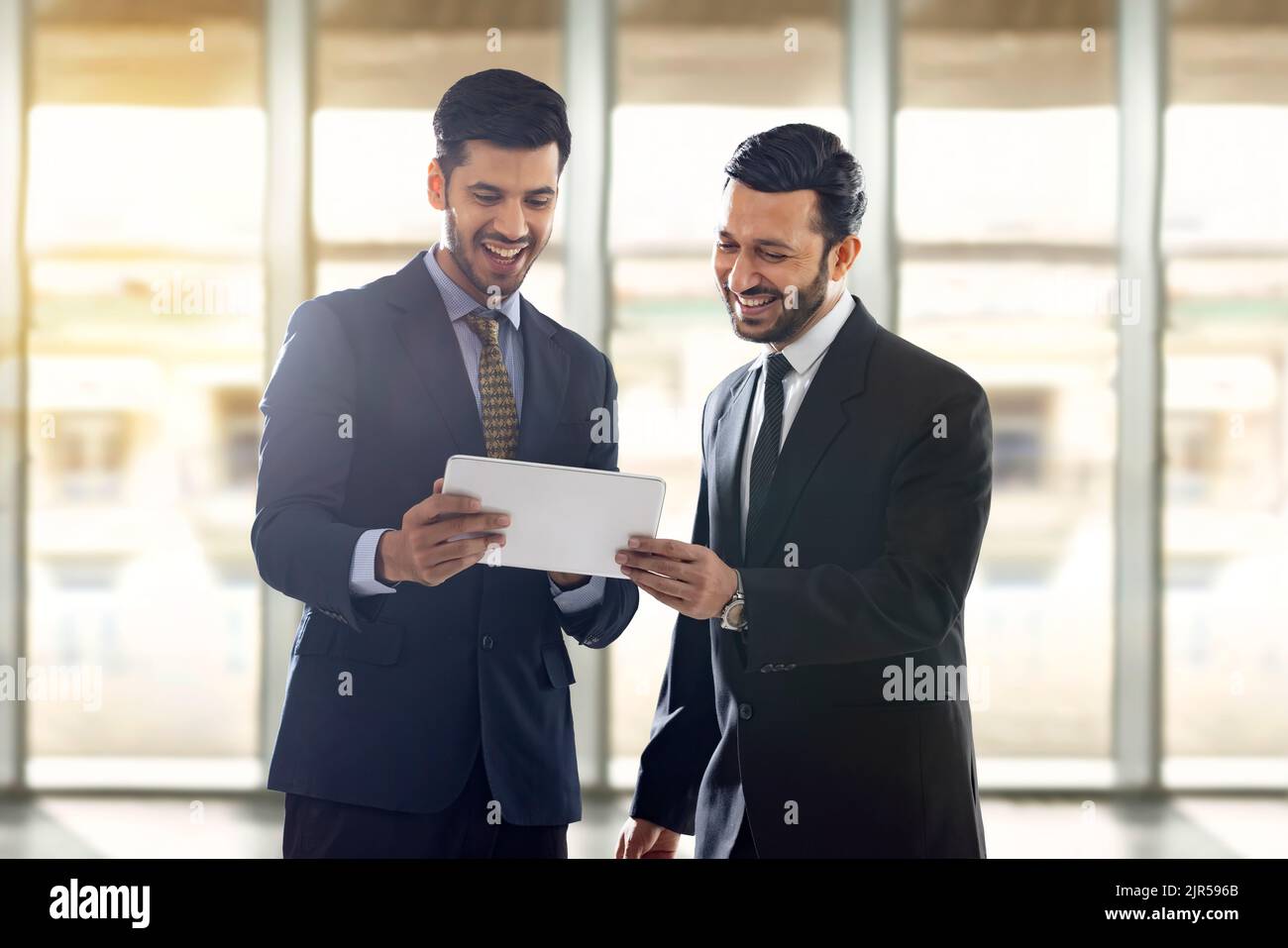 Corporate employees in formal business suit looking at a digital tablet ...