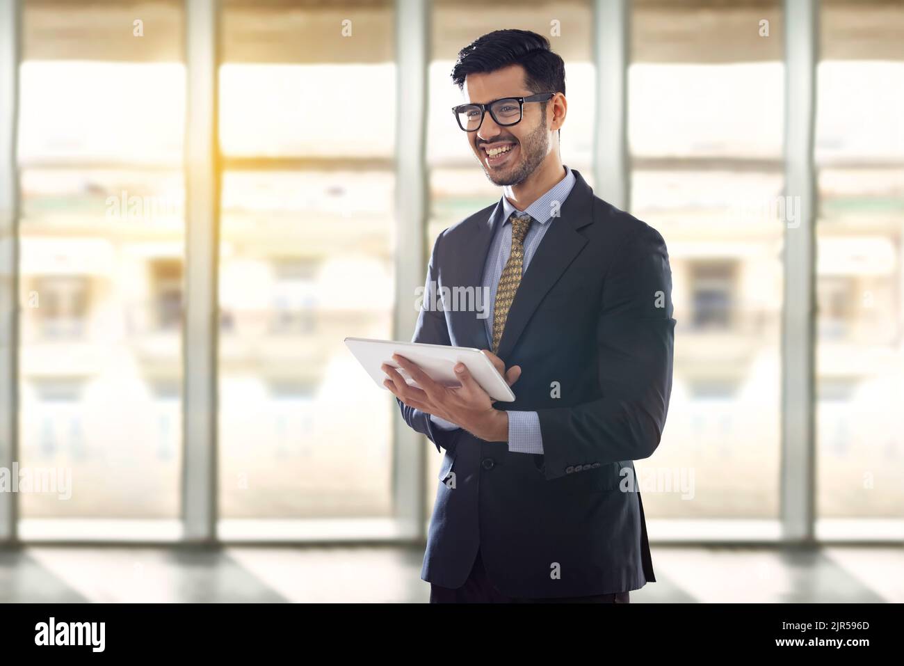 A corporate employee in formal business suit holding a digital tablet ...