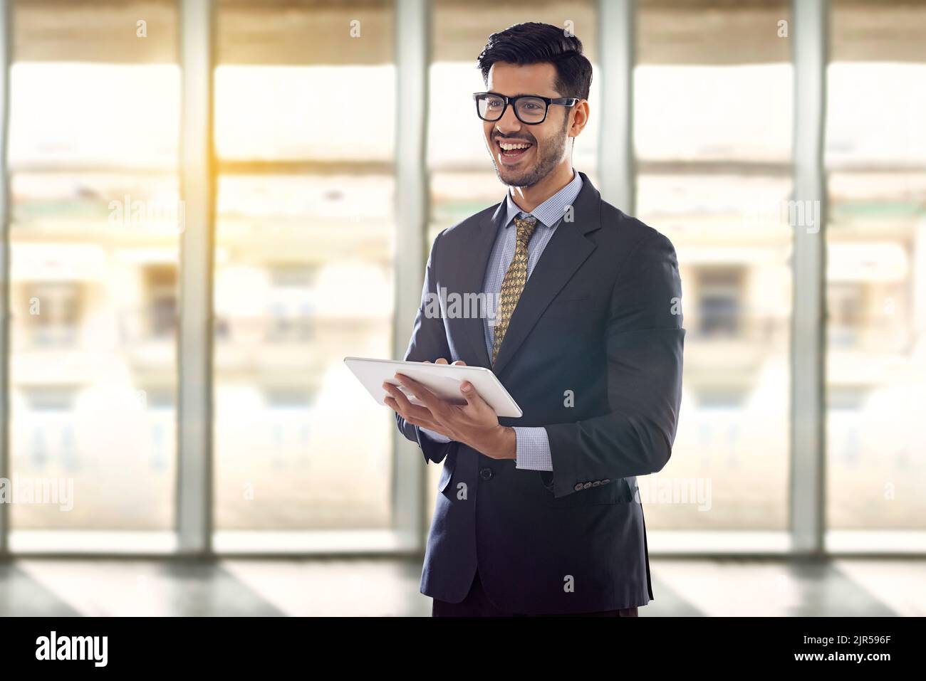 A corporate employee in formal business suit holding a digital tablet ...