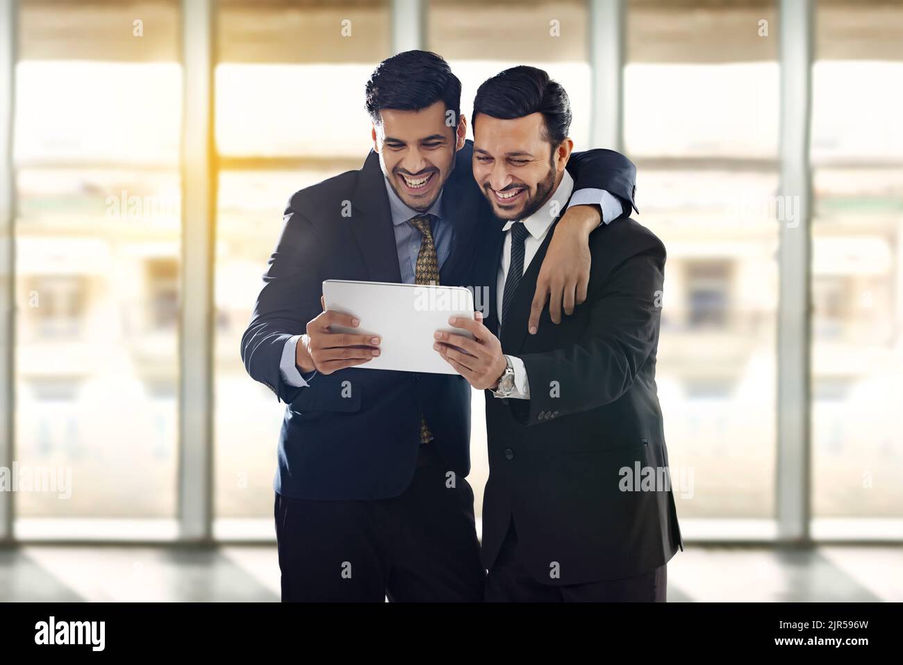 Corporate employees in formal business suit looking at a digital tablet ...