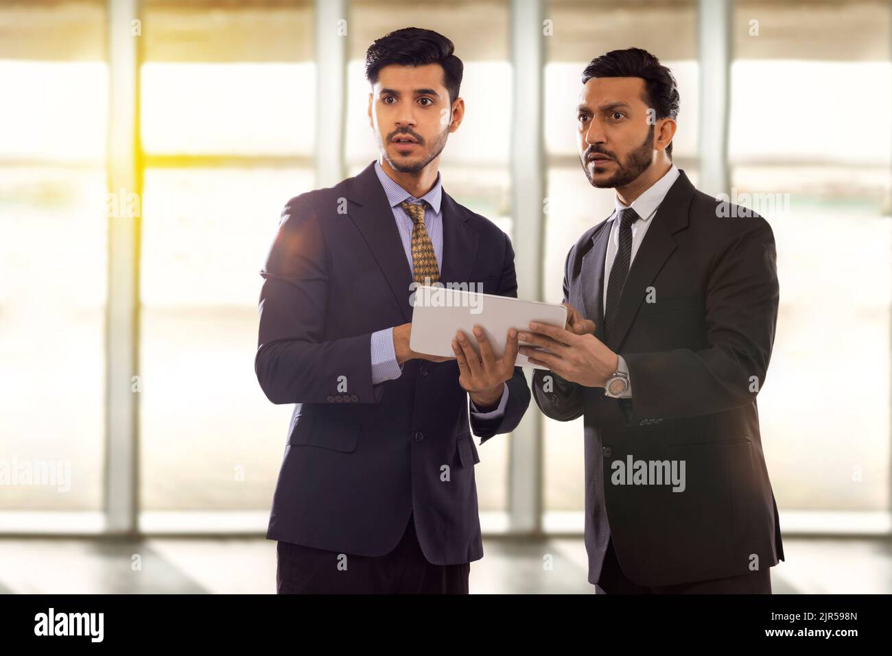 Corporate employees in formal business suit holding a digital tablet ...