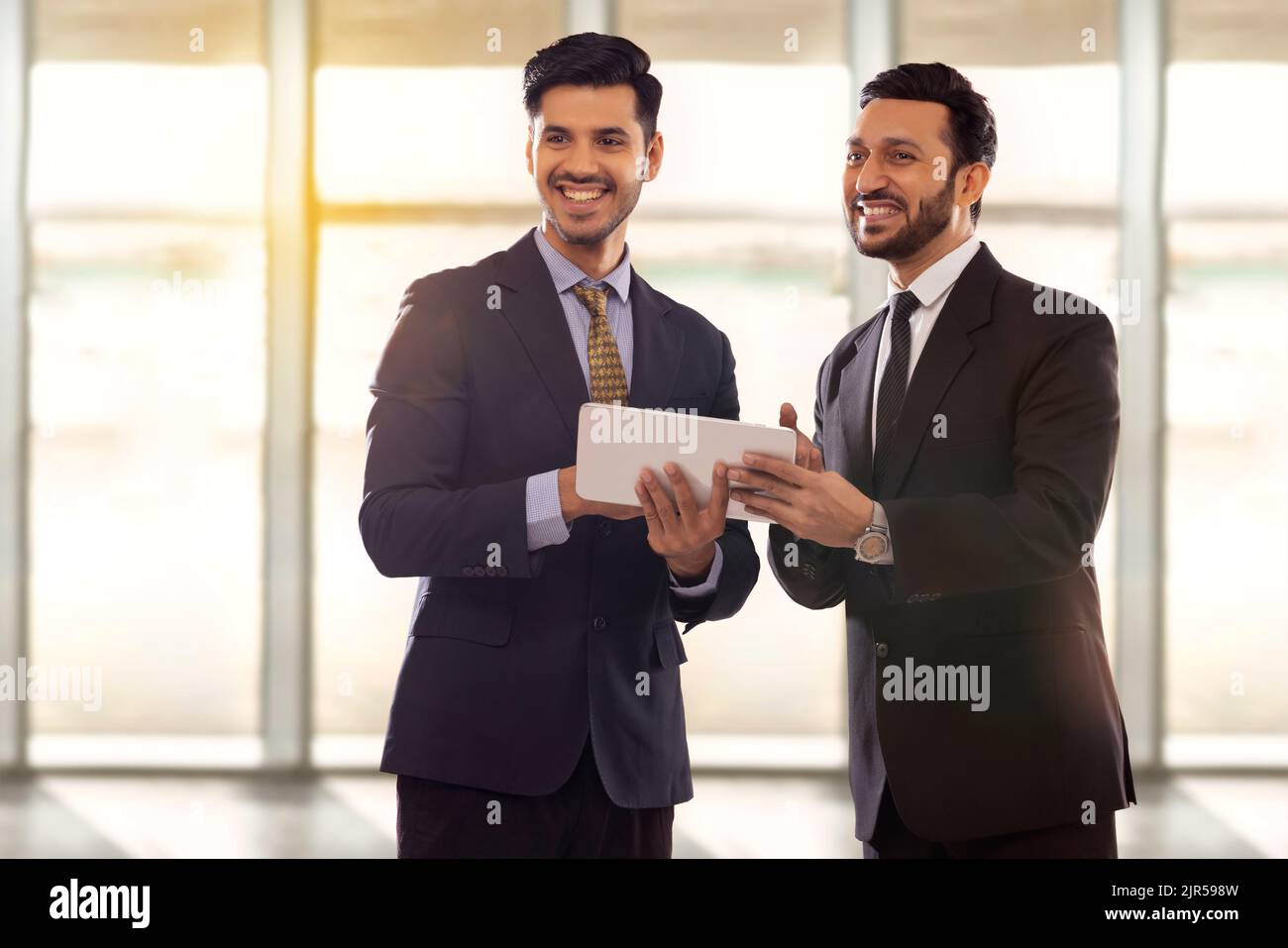 Corporate employees in formal business suit holding a digital tablet ...