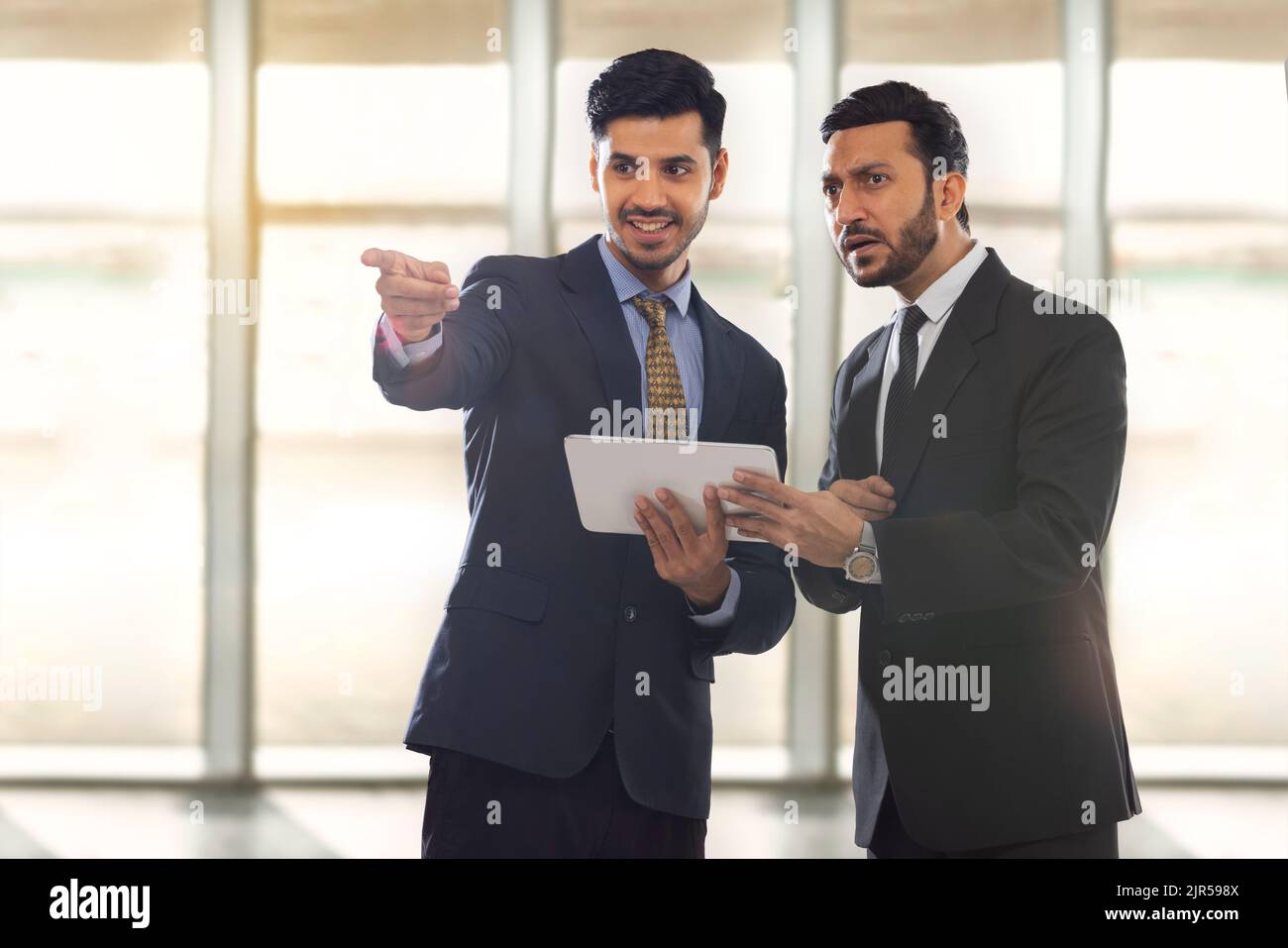 Corporate employees in formal business suit holding a tablet,with one ...