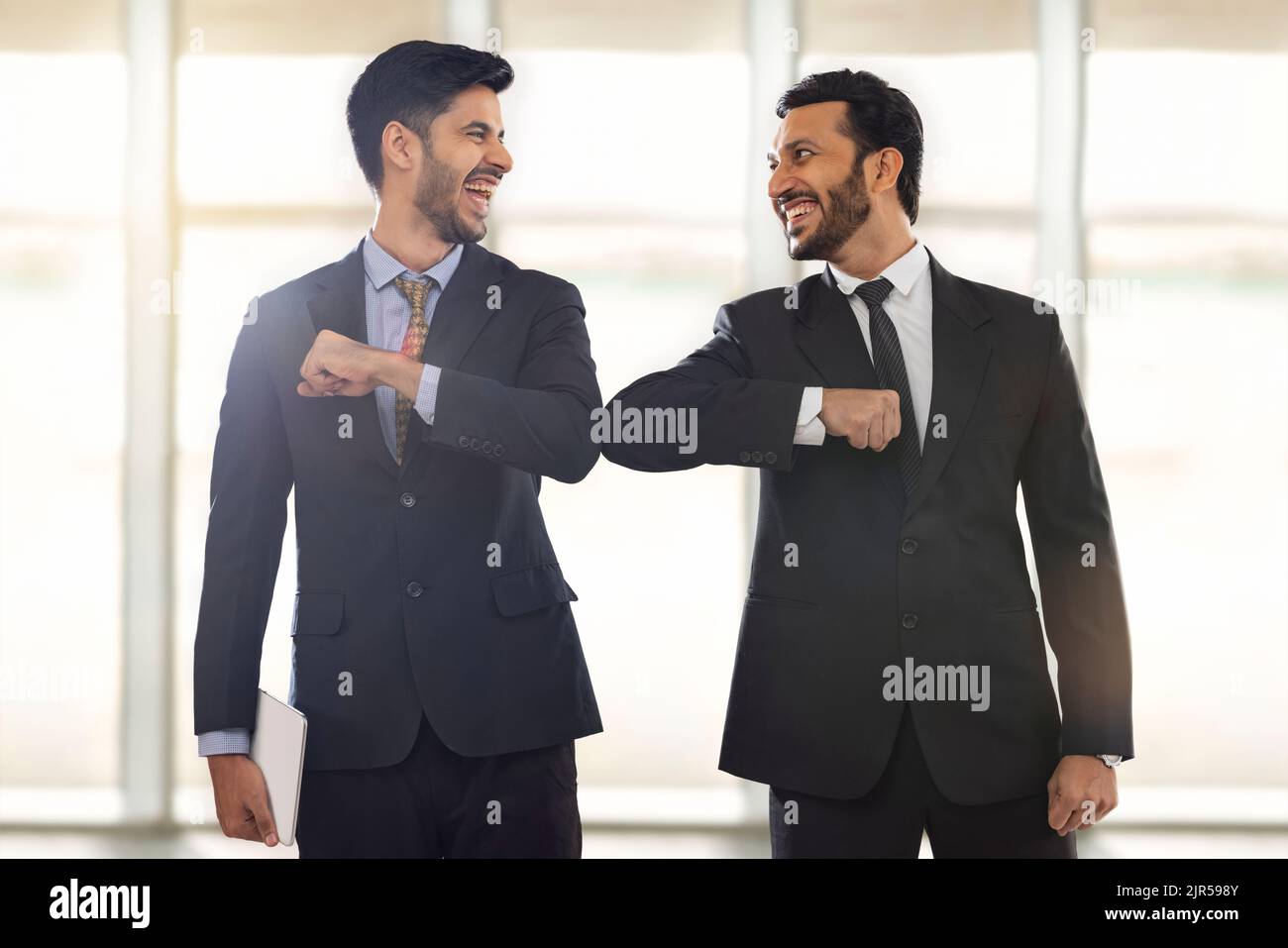 Corporate employees in formal business suit standing with their elbows ...