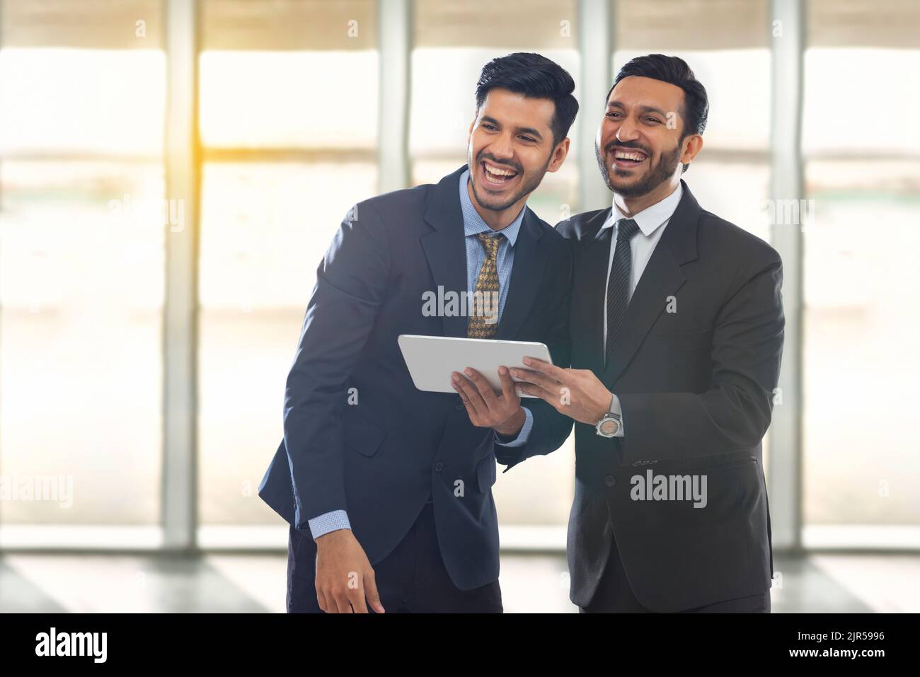 Corporate employees in formal business suit holding a digital tablet ...