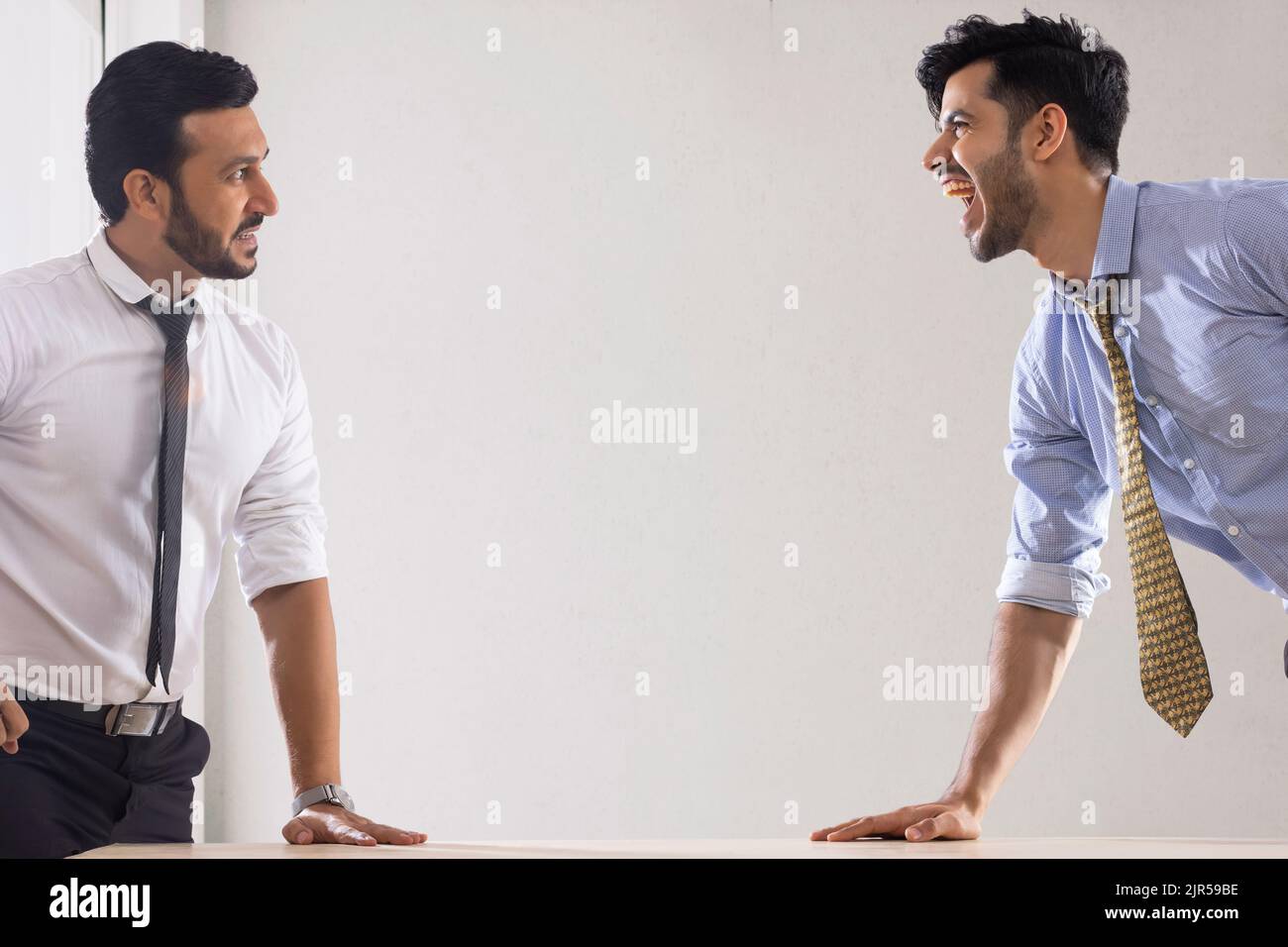 Two corporate employees in formal clothing with one of them celebrating ...