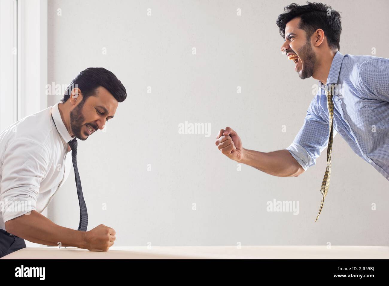 Two corporate employees in formal clothing with one of them celebrating ...
