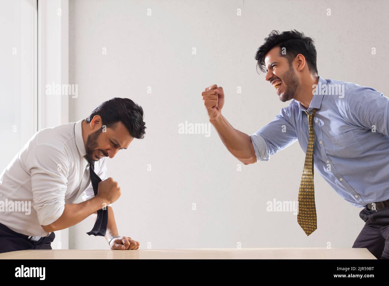 Two corporate employees in formal clothing with one of them celebrating ...