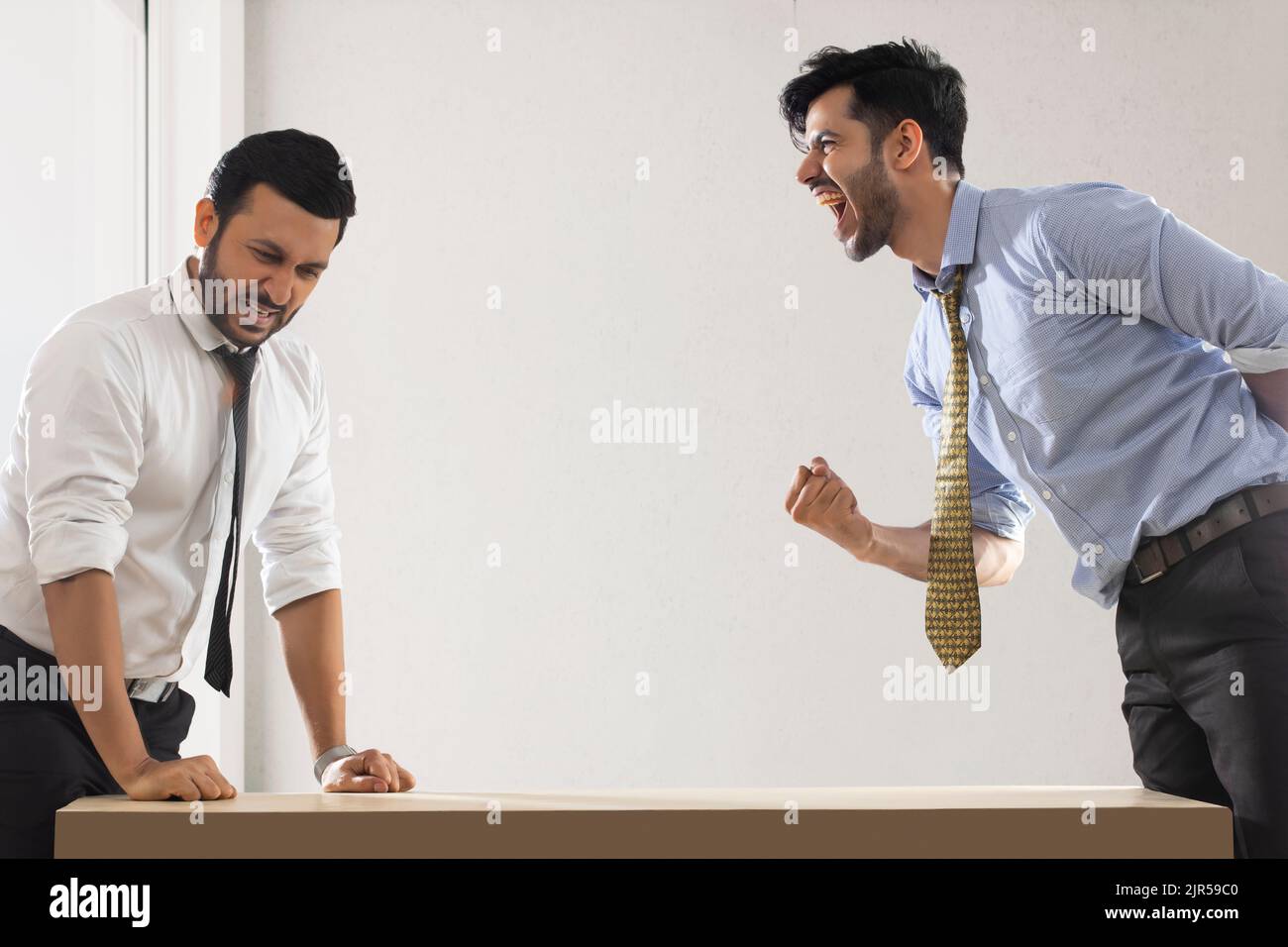 Two corporate employees in formal clothing with one of them celebrating ...