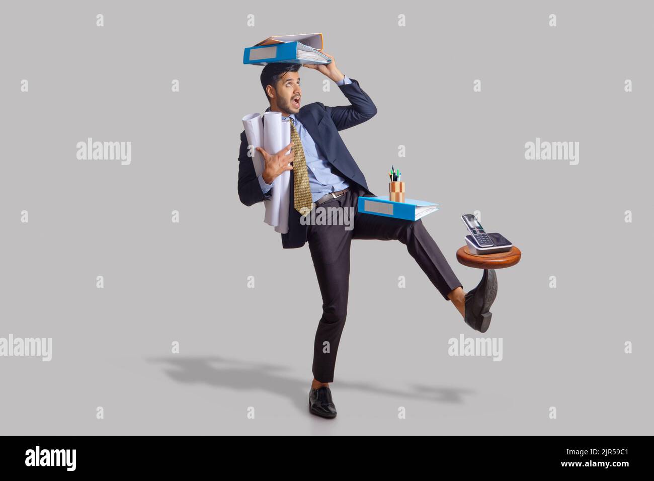 Portrait of an employee in formal clothing carefully balancing files ...