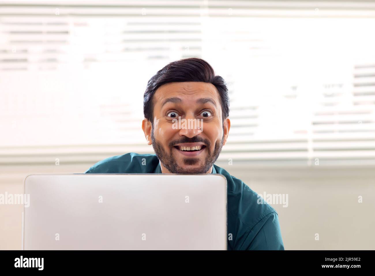 A corporate employee in formal clothing sitting behind laptop with ...