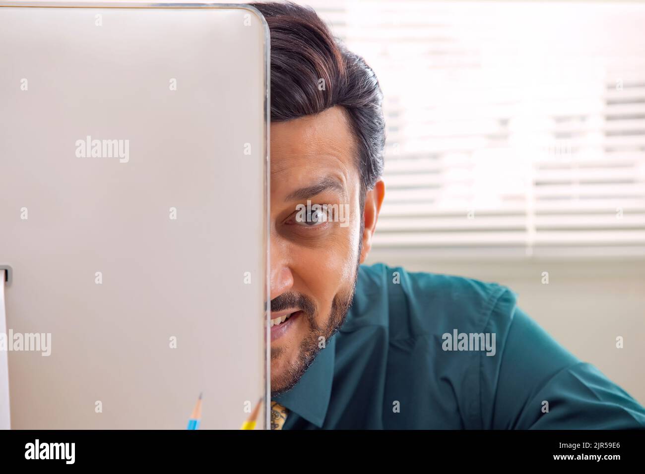 A corporate employee's face partially visible peeping out from the ...