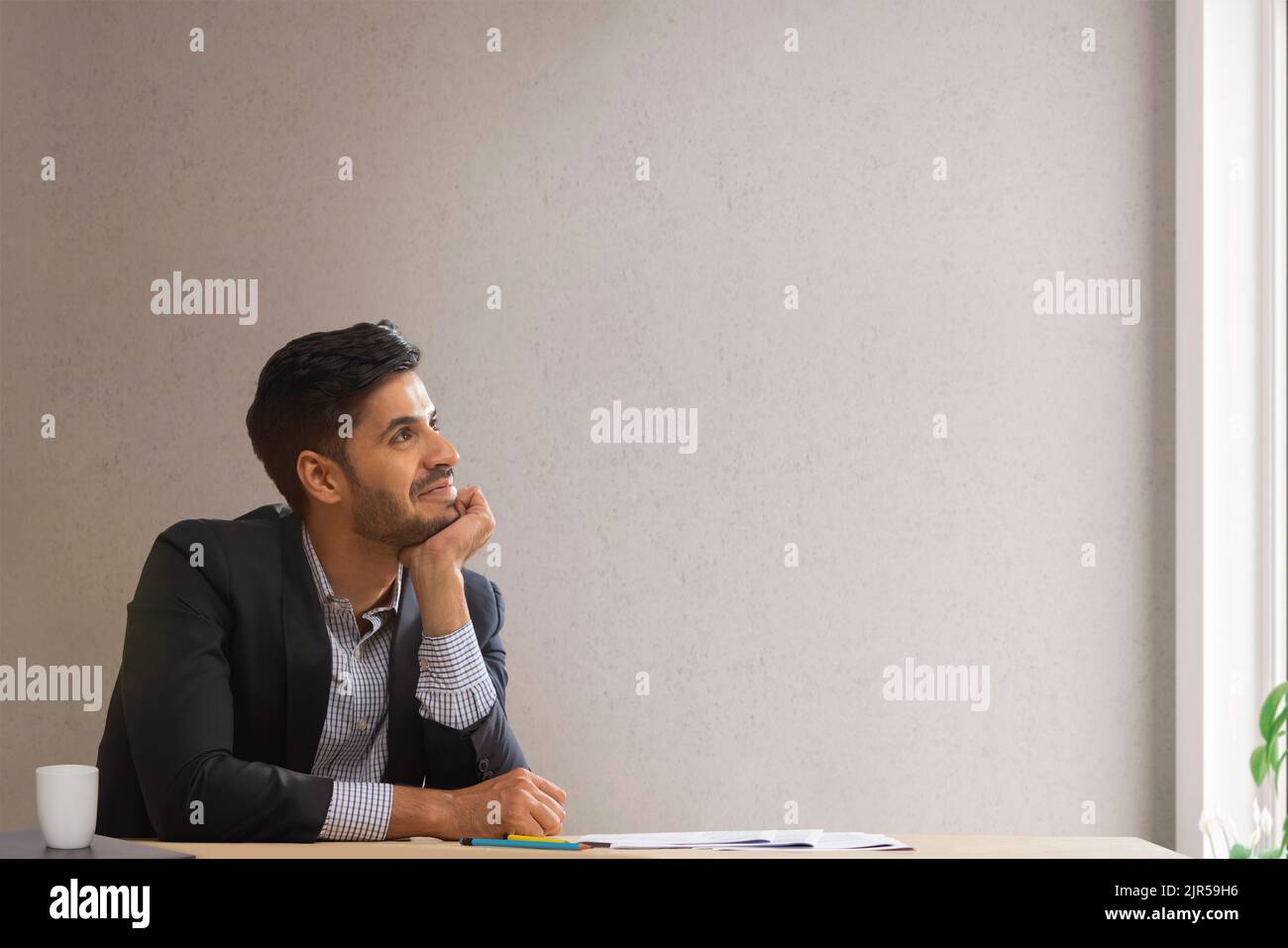 A corporate employee in formal business suit thinking while gazing ...