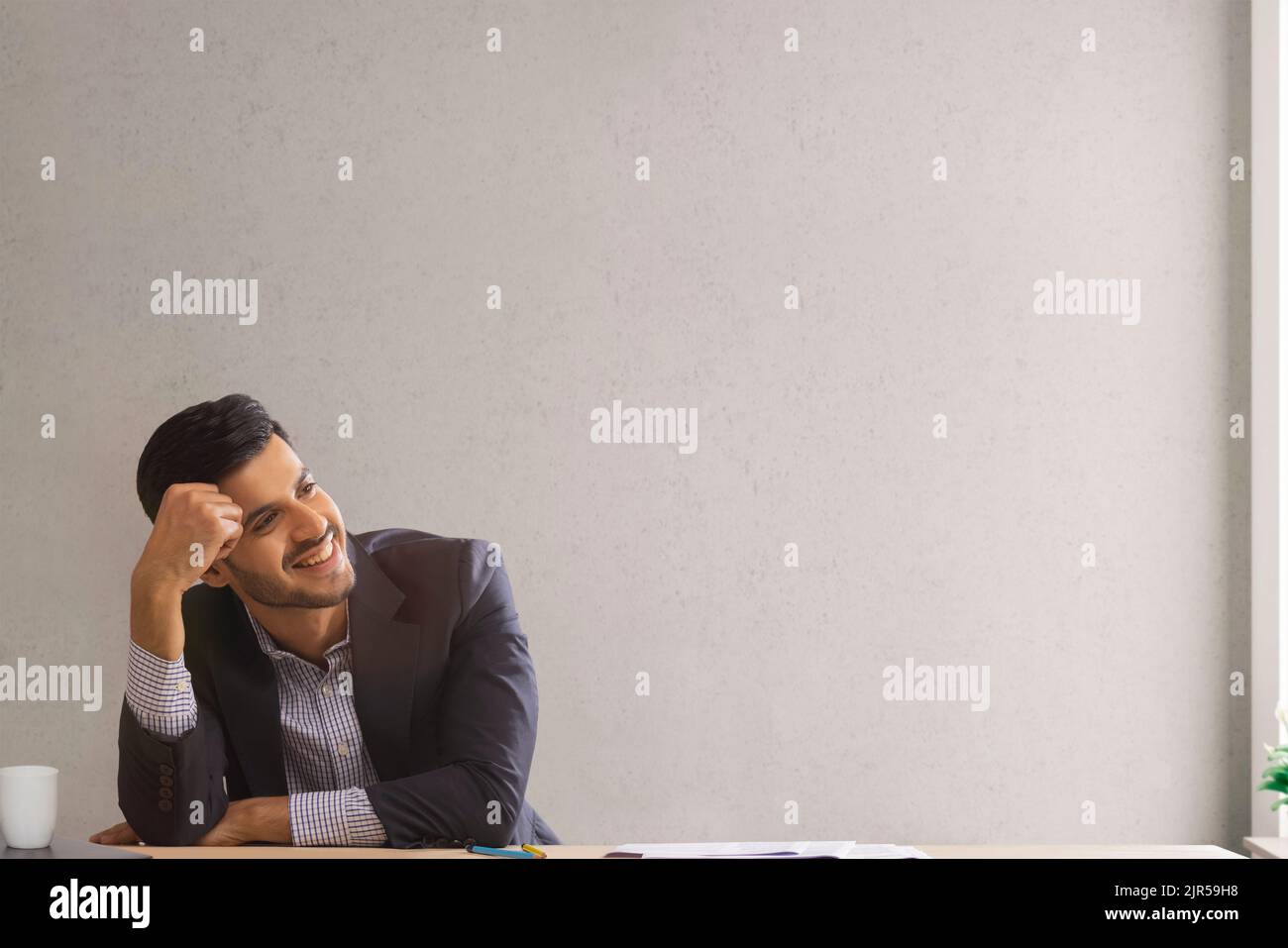 A corporate employee in formal business suit sitting and daydreaming ...