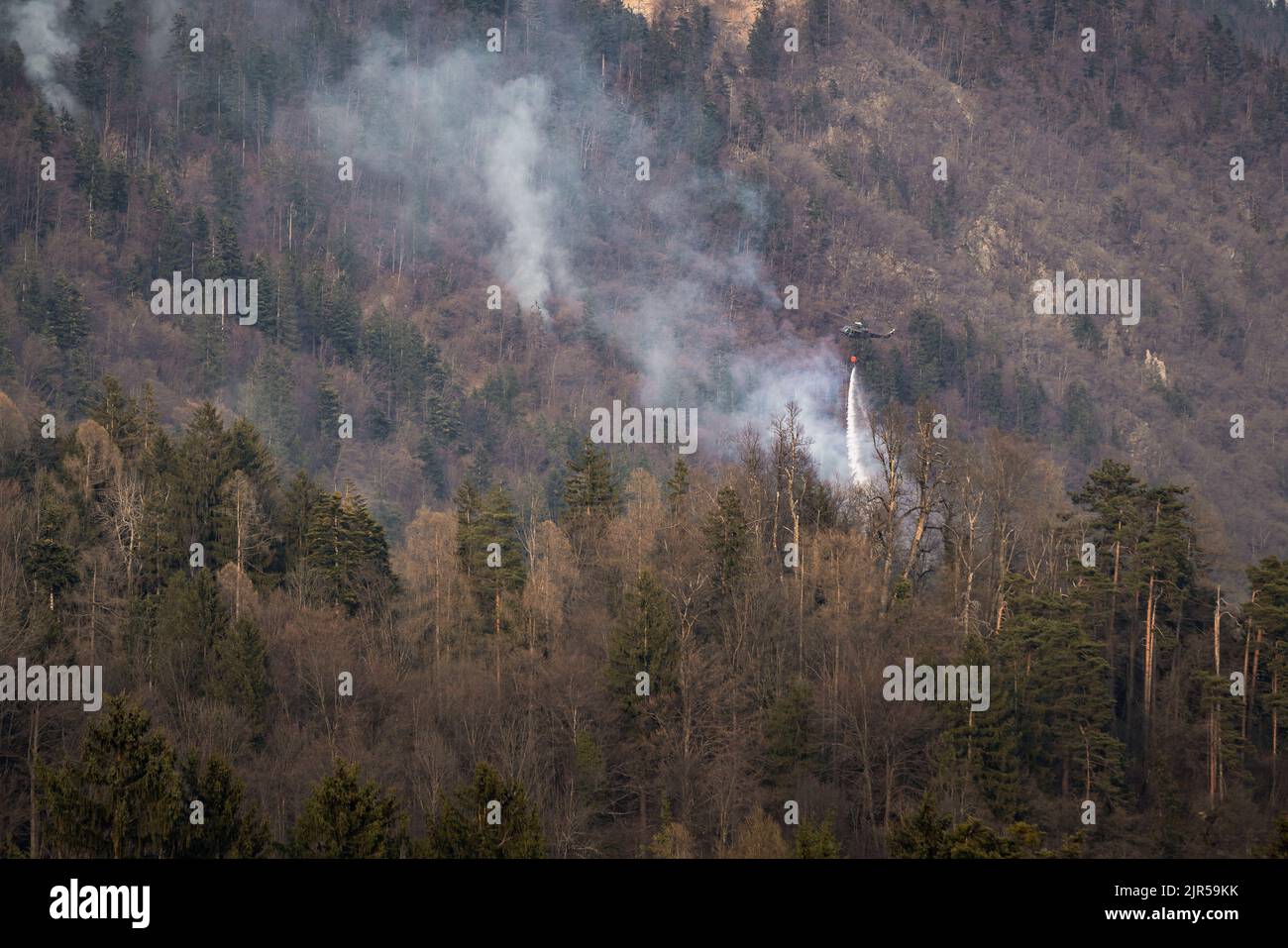 Localized wildfire with the helicopter dropping water by using a water ...